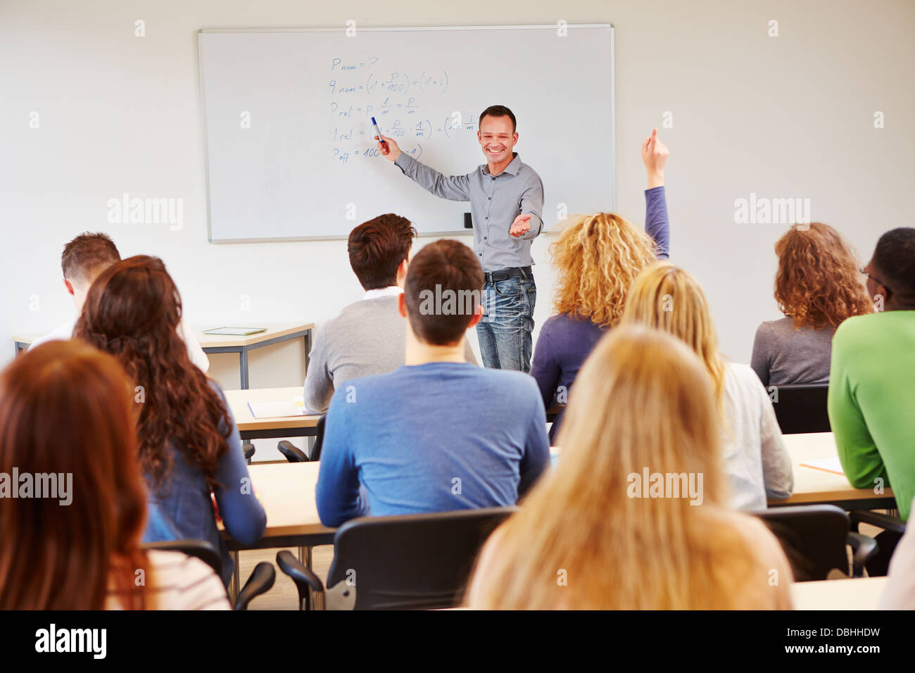 Student raising hand in school class and getting called by teacher ...