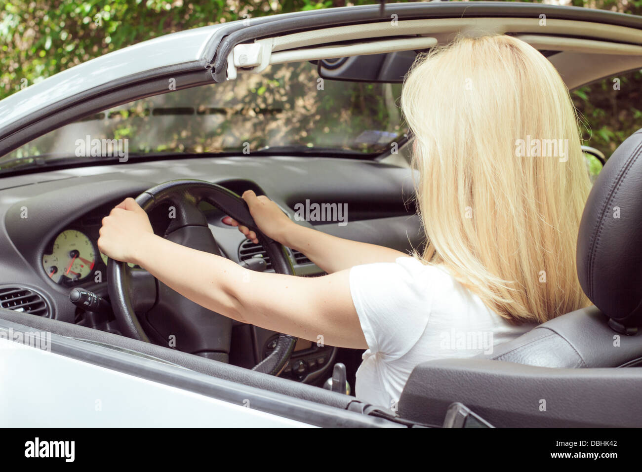 Young blond woman in a car, rear view Stock Photo - Alamy