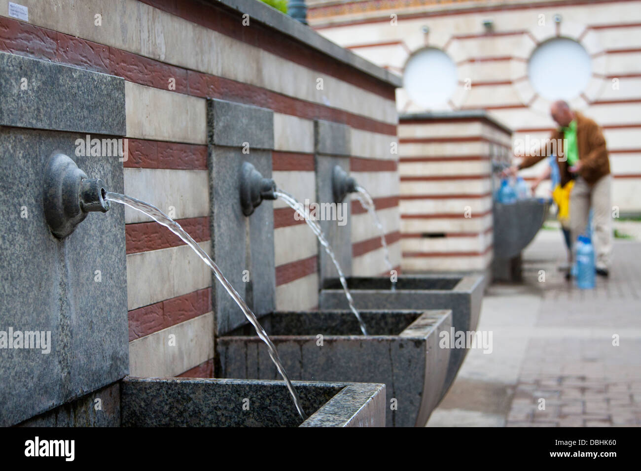 Man filling bottles at the hot mineral water springs in central Sofia ...