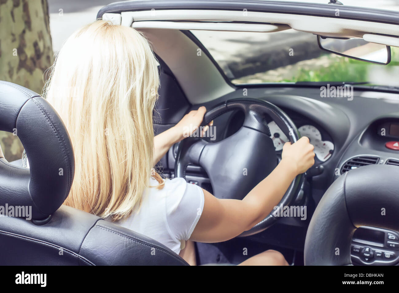 Young blond woman in a car, rear view Stock Photo - Alamy