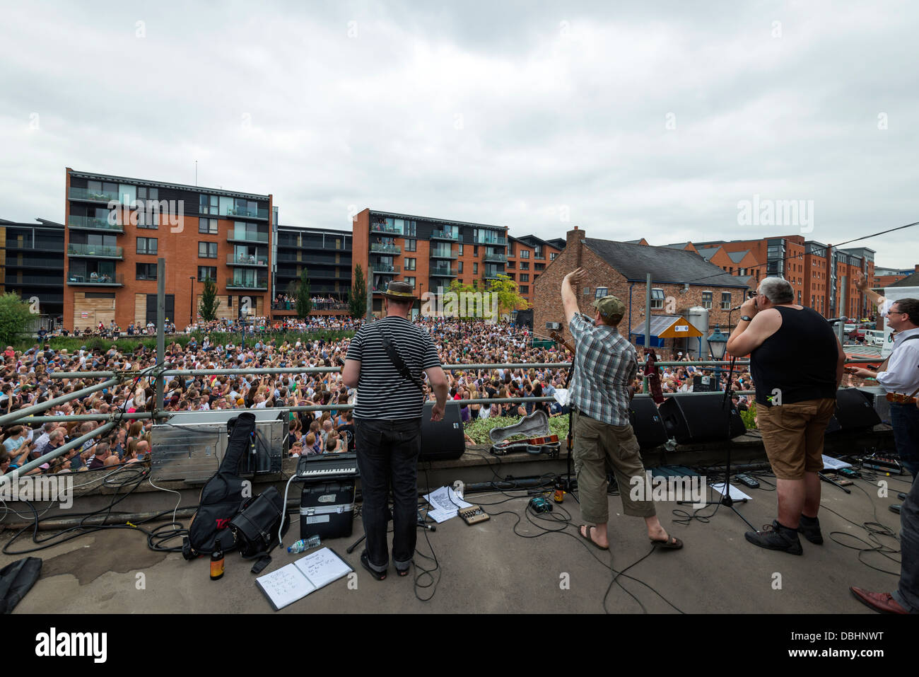 Band playing on top of roof with large crowd of people watching at ...
