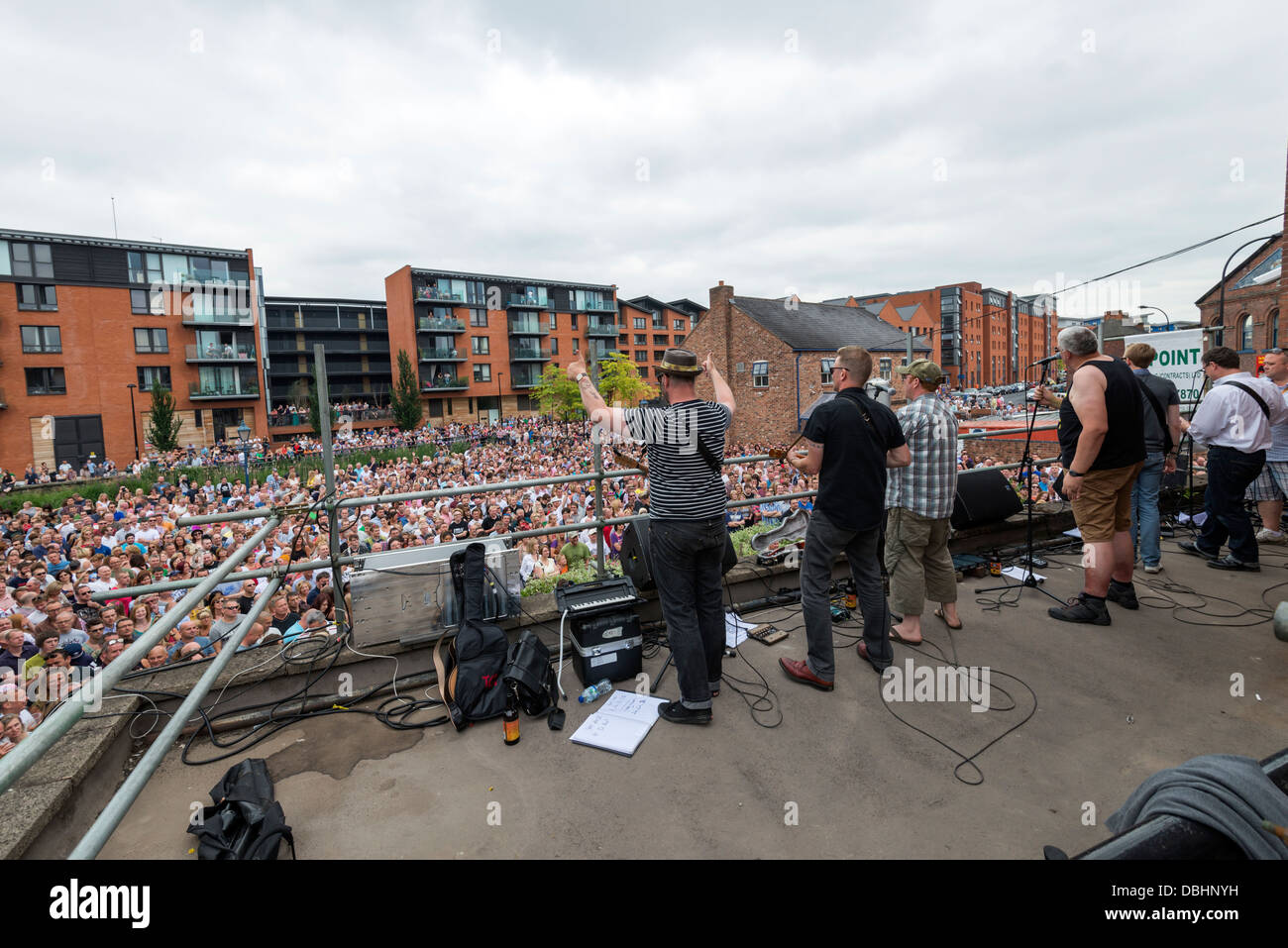 Band playing on top of roof with large crowd of people watching at ...