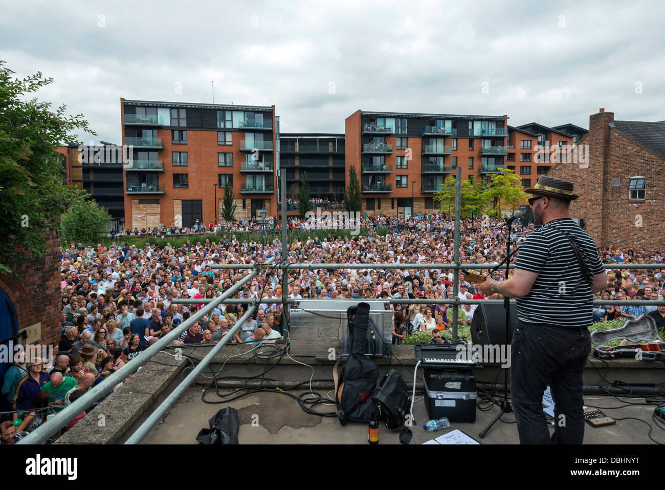 Band playing on top of roof with large crowd of people watching at ...