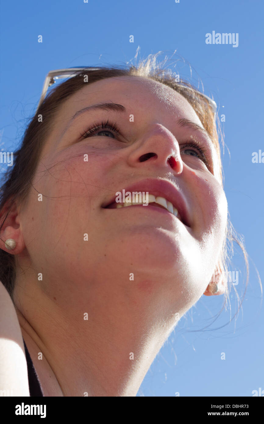 Young Happy Woman Smiling Cheerfully In The Sun Stock Photo - Alamy