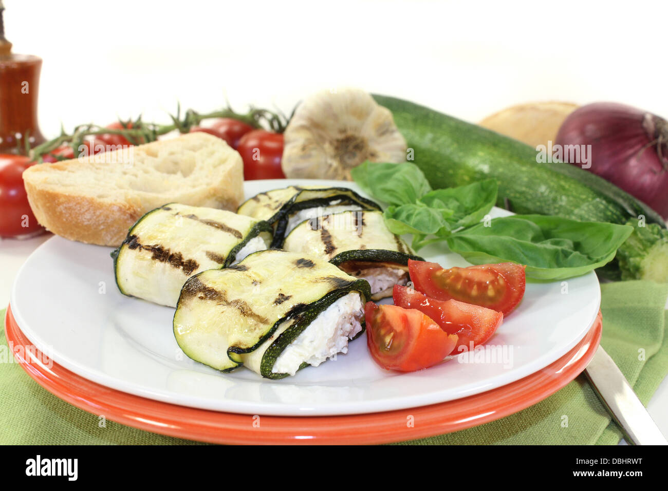 stuffed courgette rolls and tomatoes on a white plate Stock Photo - Alamy
