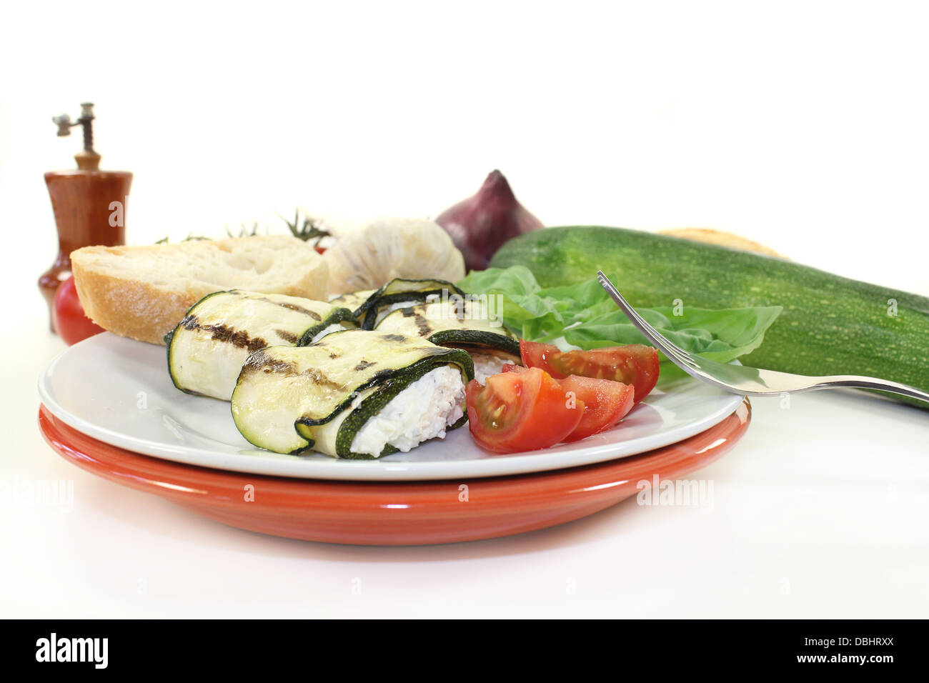 stuffed courgette rolls and tomatoes on a white plate Stock Photo - Alamy