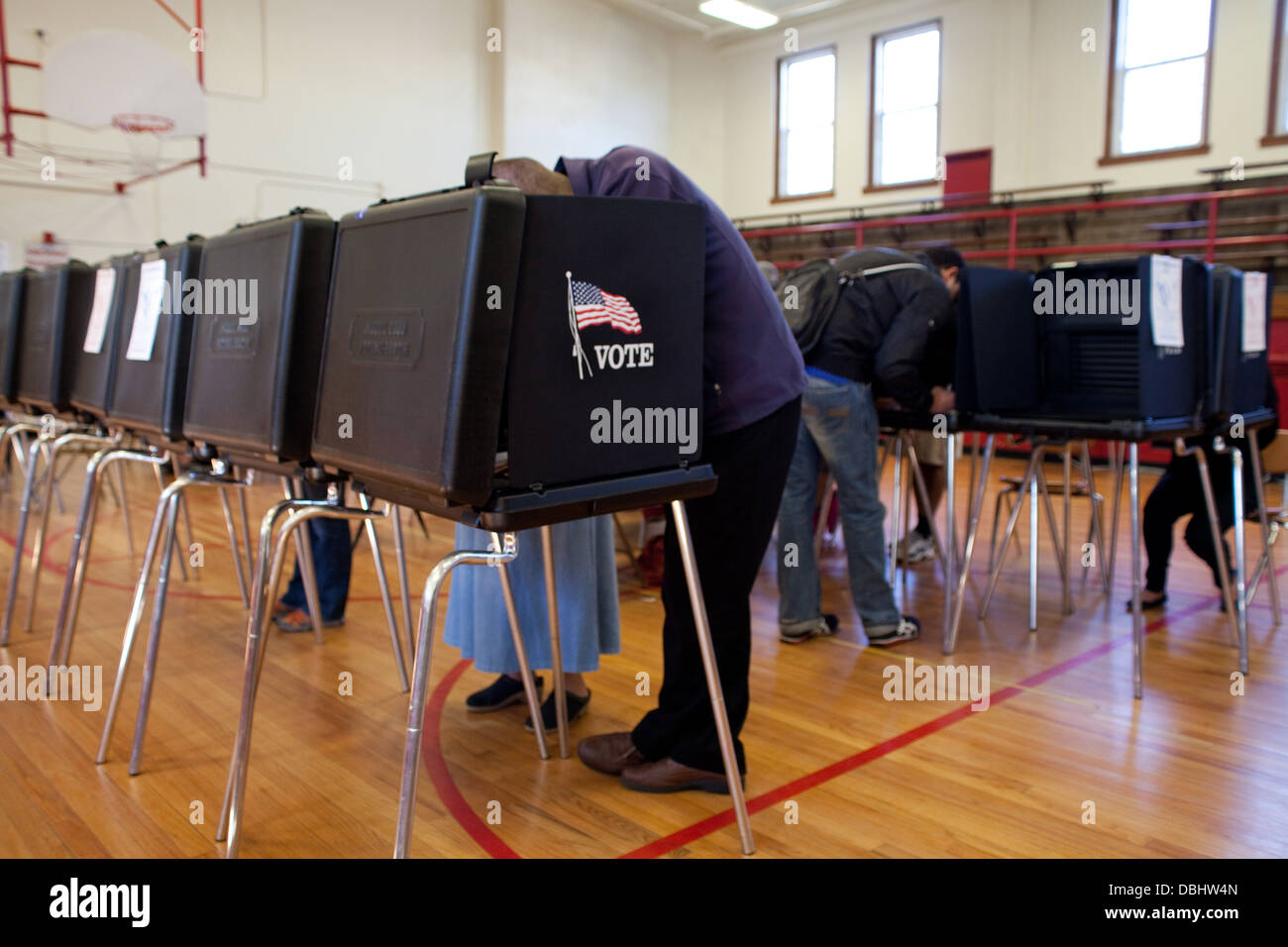 People casting their vote in a school gymnasium, USA, 2012 election day ...