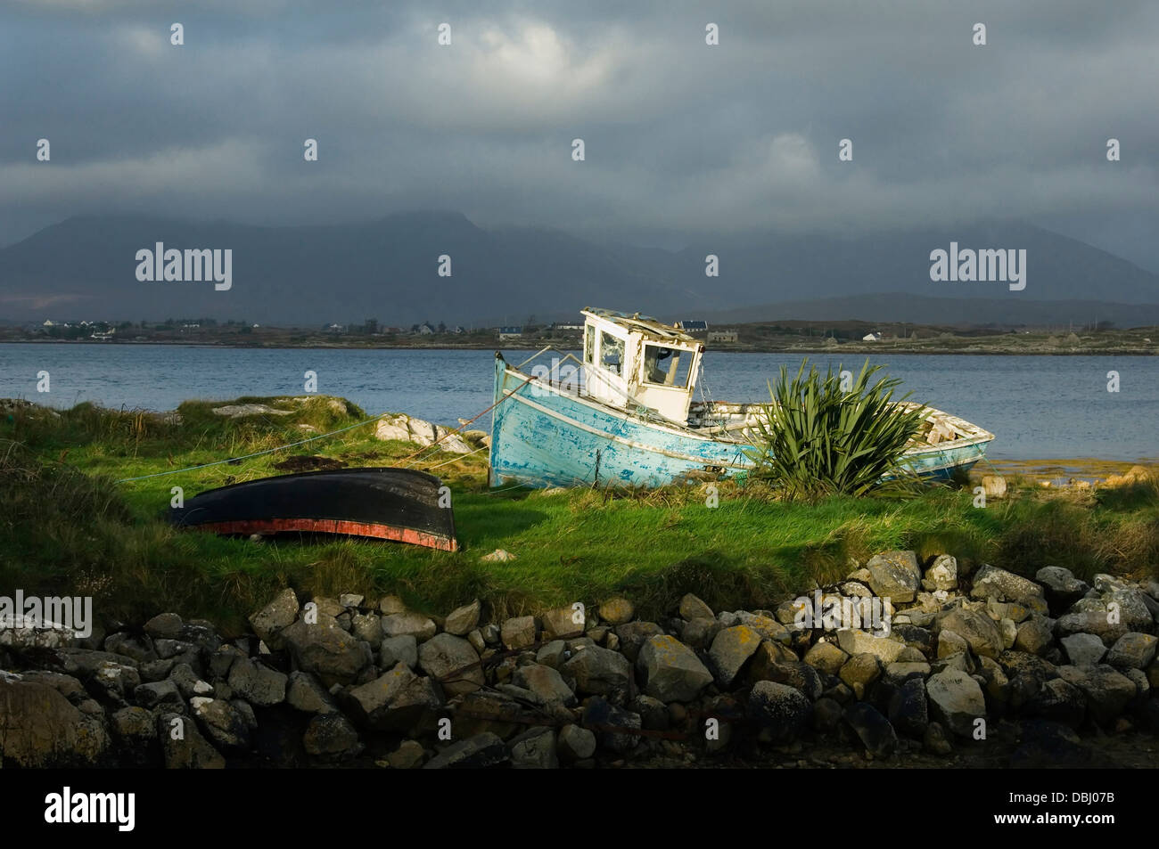 A disused small fishing boat drawn up on the grass at Roundstone ...