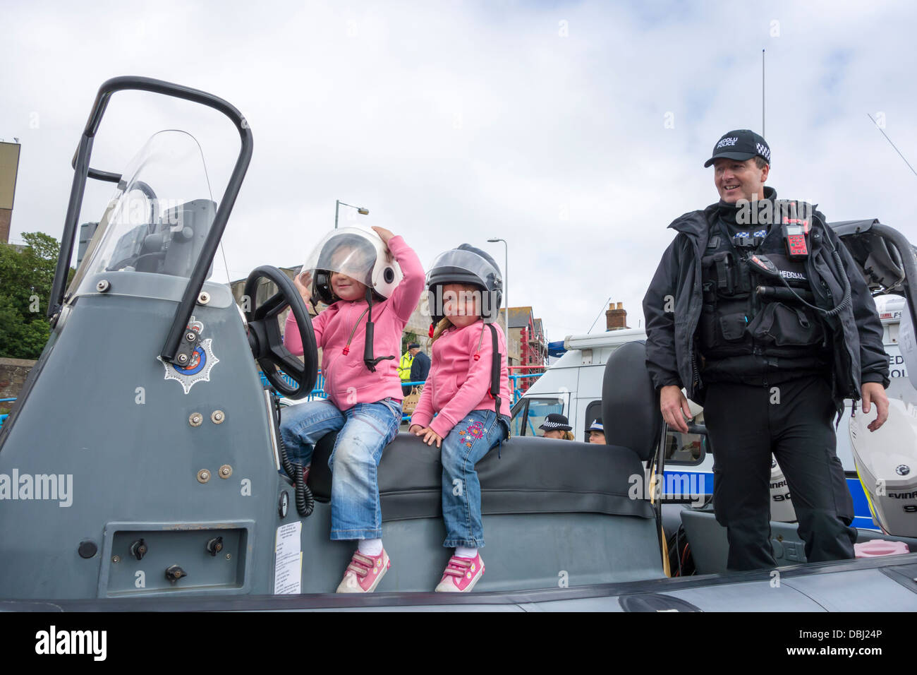 Two young girls sitting on a police boat at the Pembrokeshire Fish Week ...
