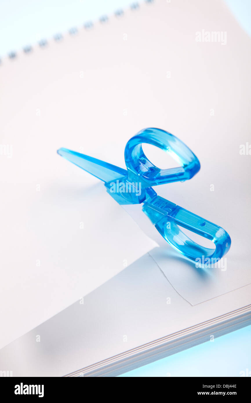 Scissors cutting paper Stock Photo - Alamy