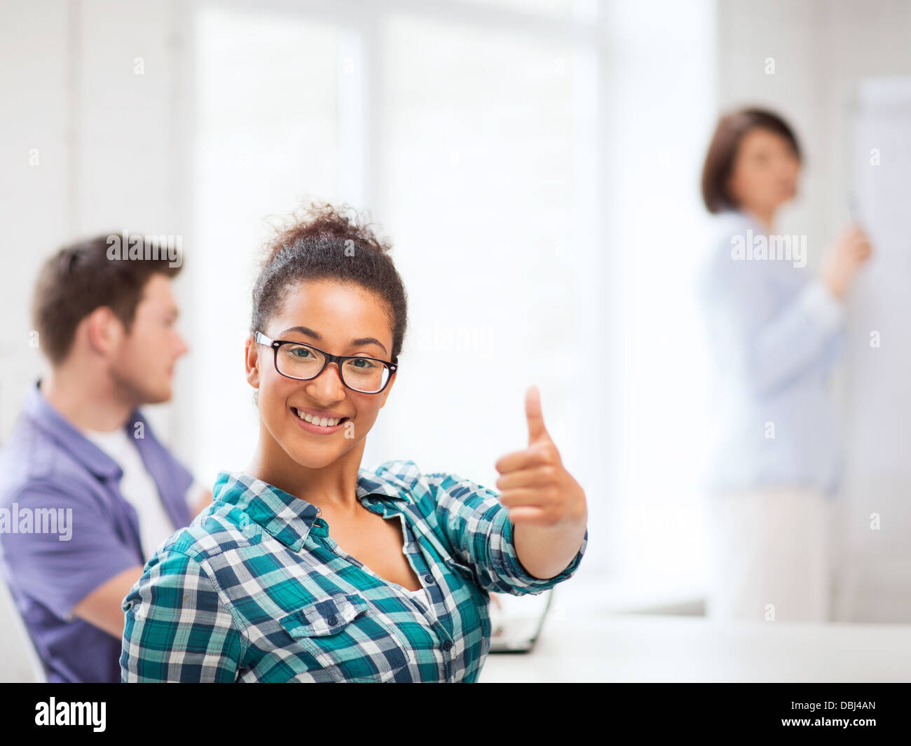 african student girl showing thumbs up Stock Photo - Alamy