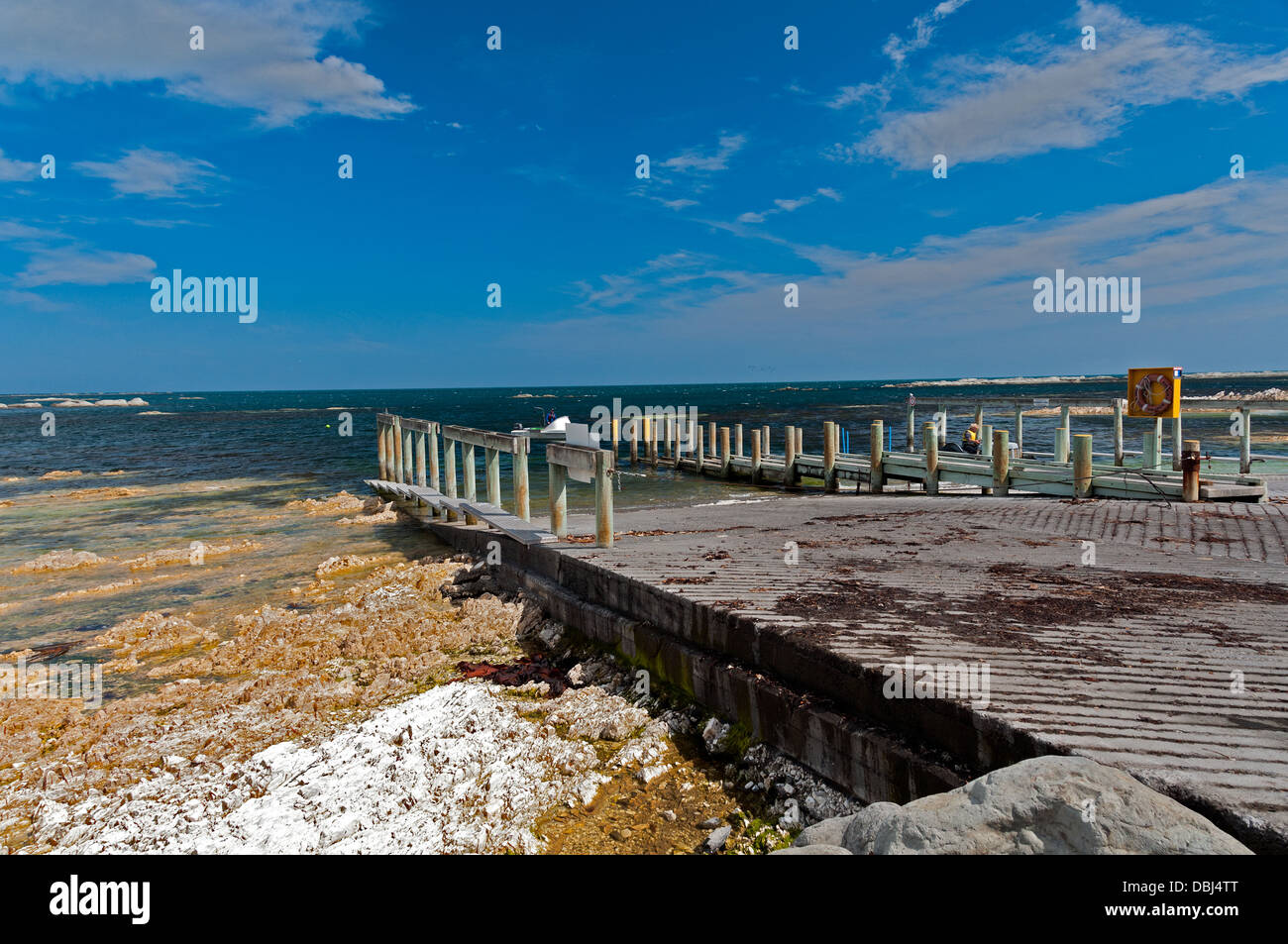 Kaikoura jetty with rocks into shallow blue sea on summers day with ...