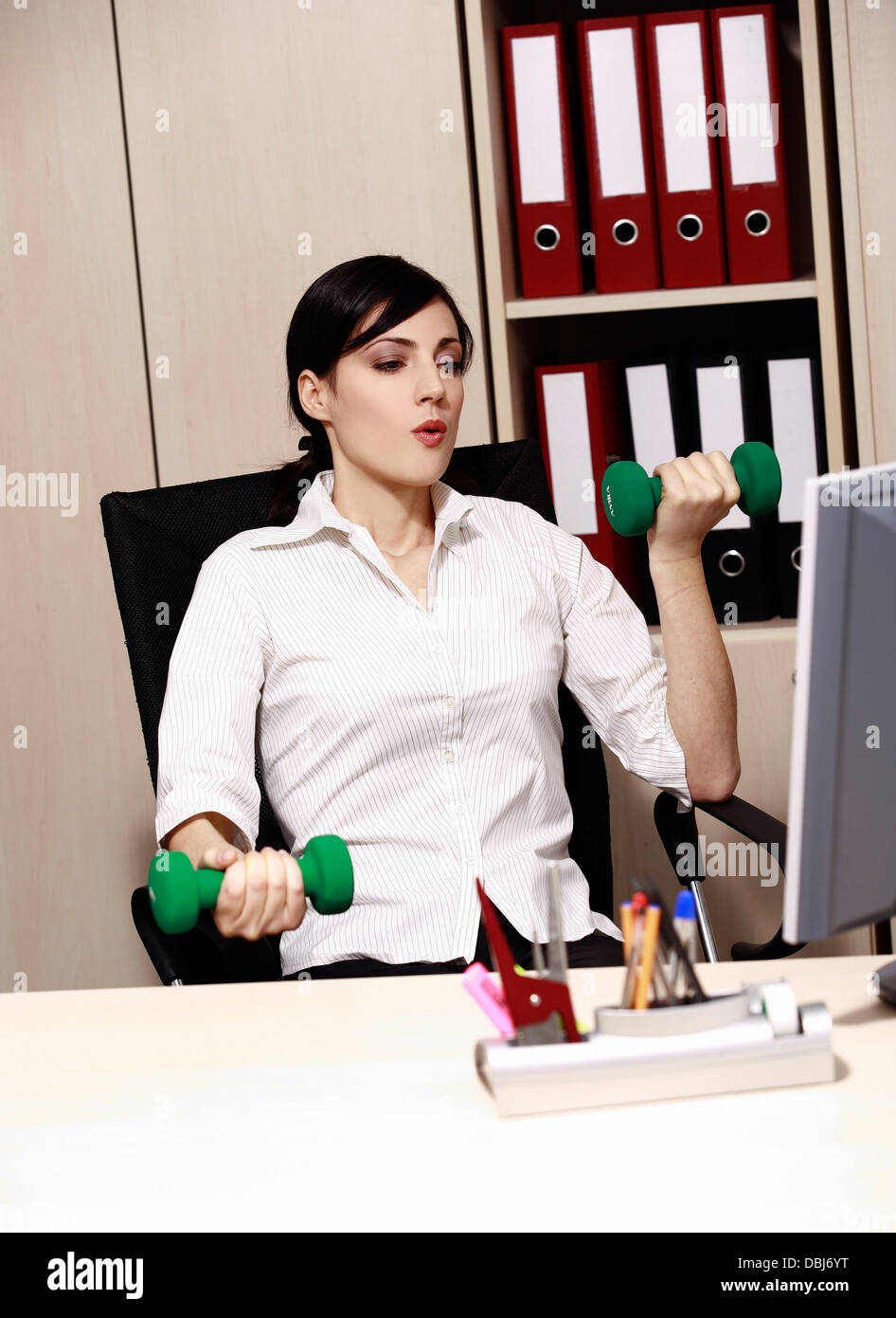 Office worker at desk weight lifting Stock Photo - Alamy
