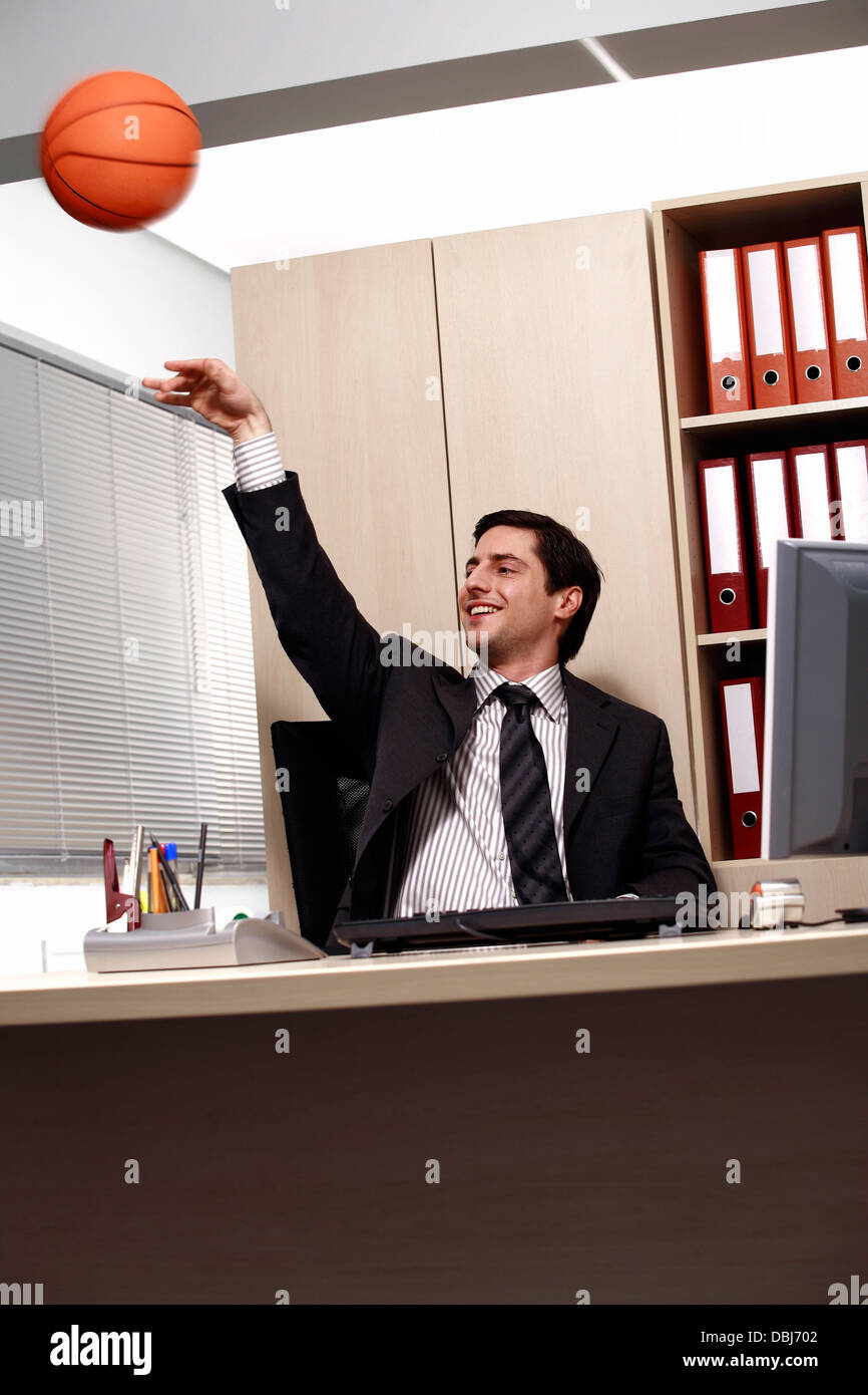 Office worker at desk playing with a basketball Stock Photo - Alamy