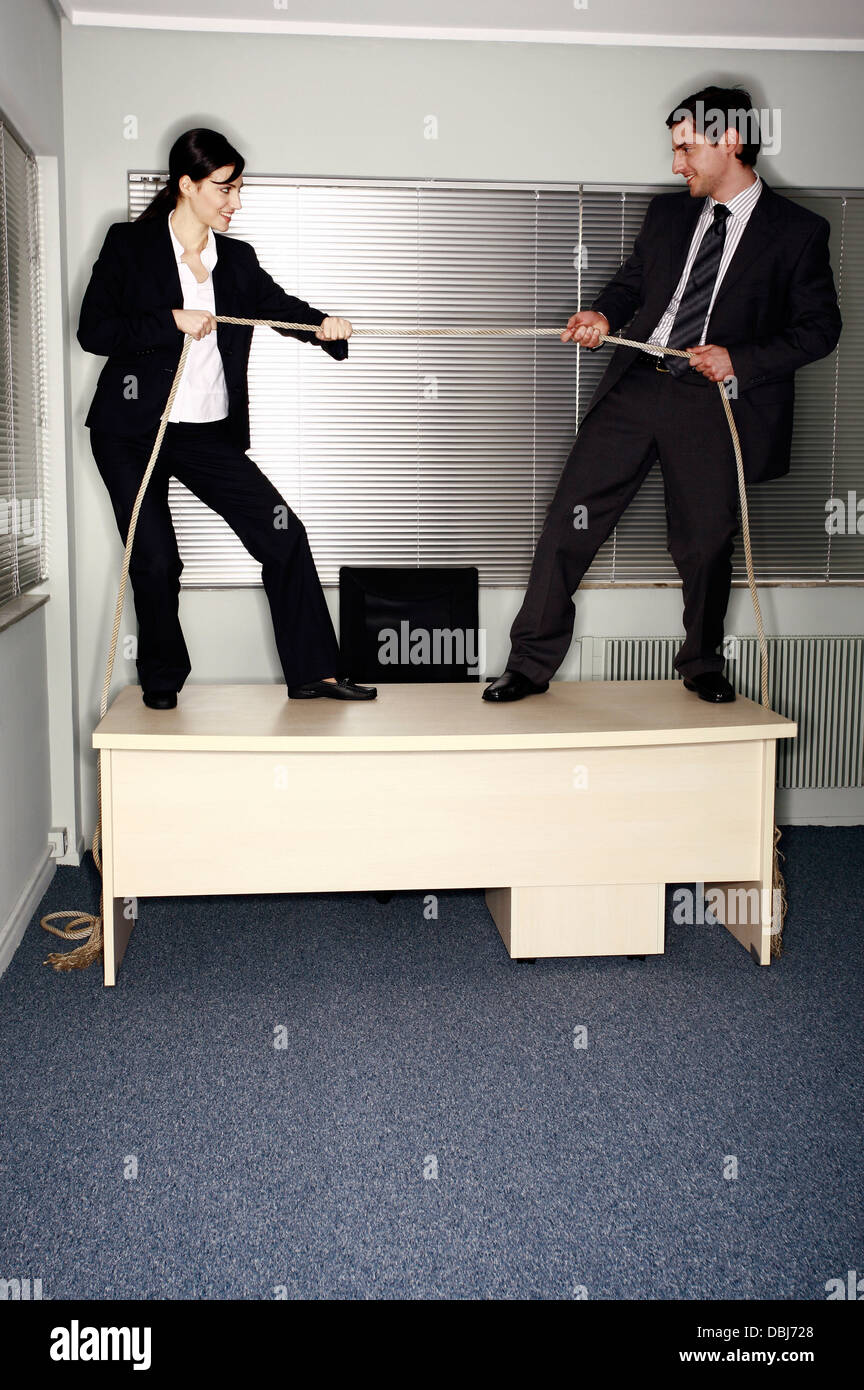 Male and female business people pulling ends of rope Stock Photo - Alamy