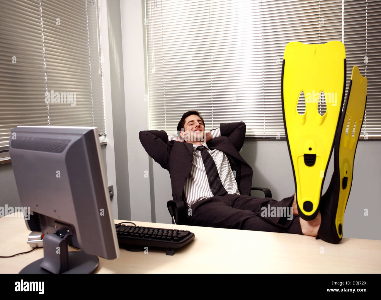 Office worker at computer wearing swim flippers Stock Photo - Alamy