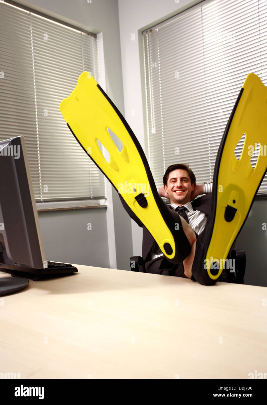 Office worker at computer wearing swim flippers Stock Photo - Alamy