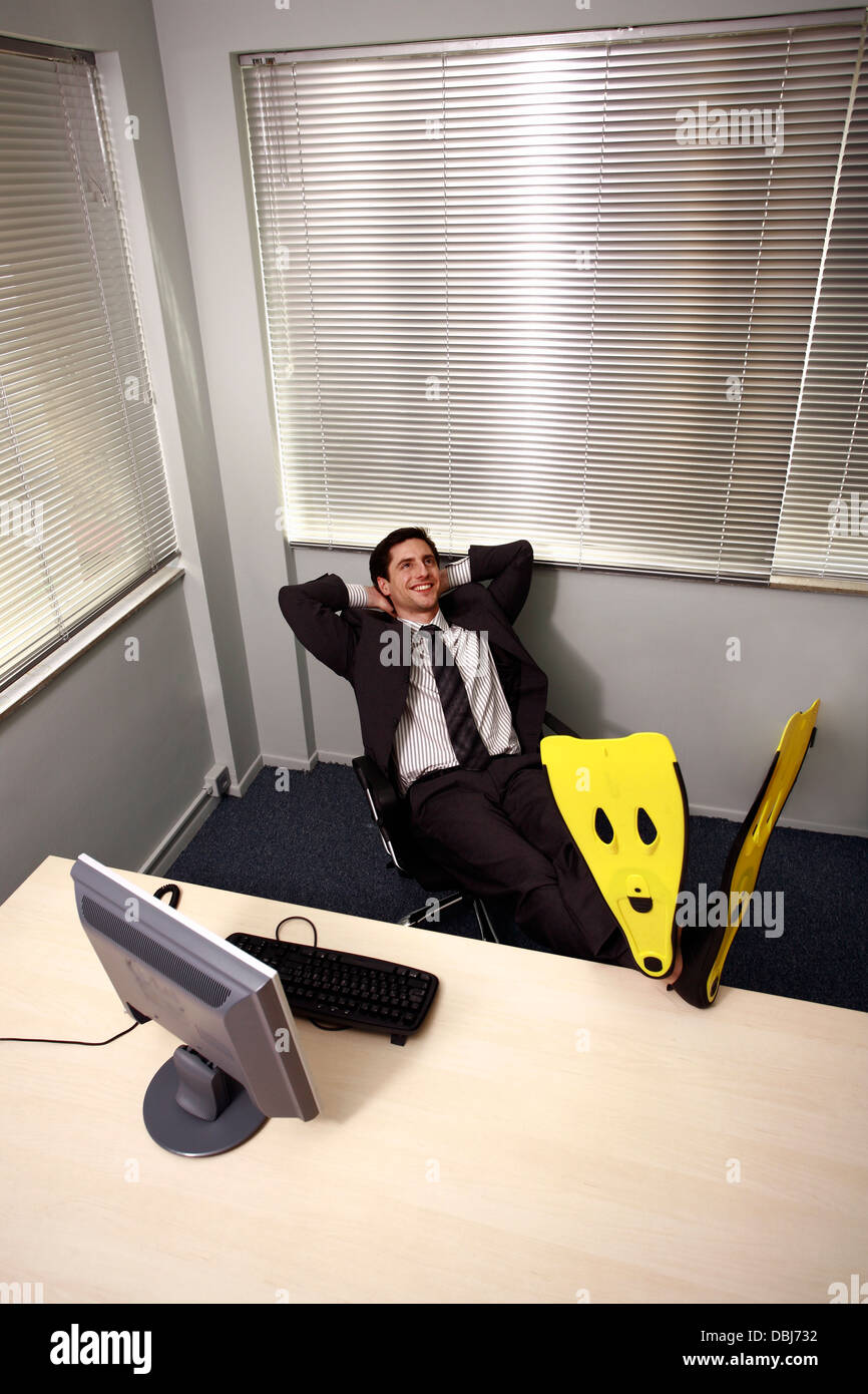 Office worker at computer wearing swim flippers Stock Photo - Alamy