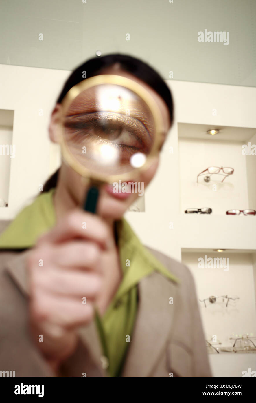 Woman with magnifying glass on eye Stock Photo - Alamy