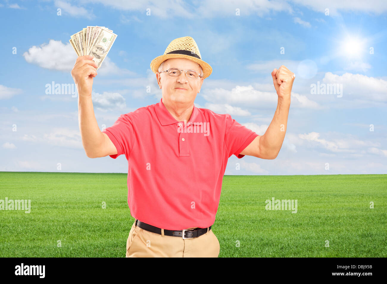 Happy senior man holding money banknotes and gesturing happiness on a ...