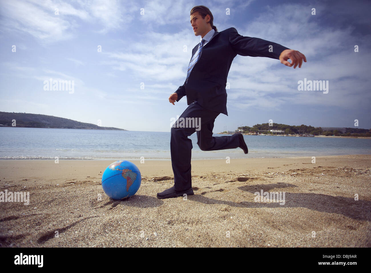 Businessman on beach with globe beach ball Stock Photo - Alamy