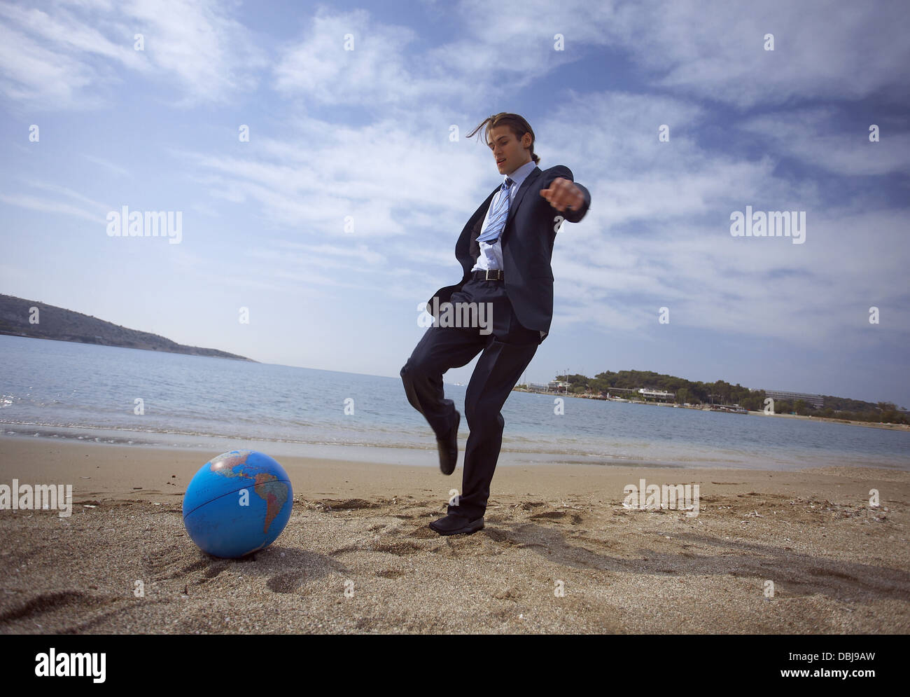 Businessman on beach with globe beach ball Stock Photo - Alamy