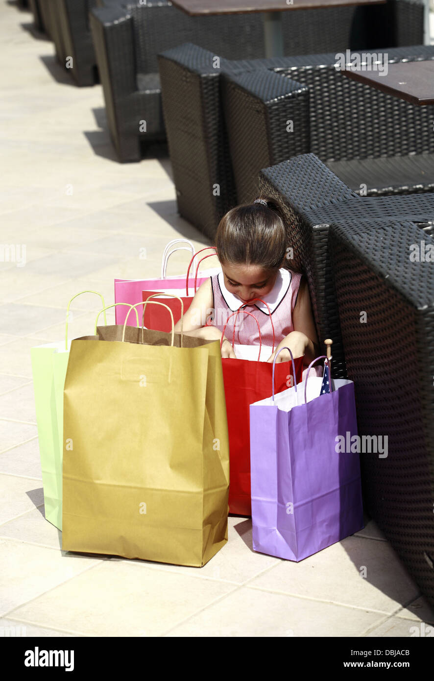 Girl looking in shopping bags Stock Photo - Alamy