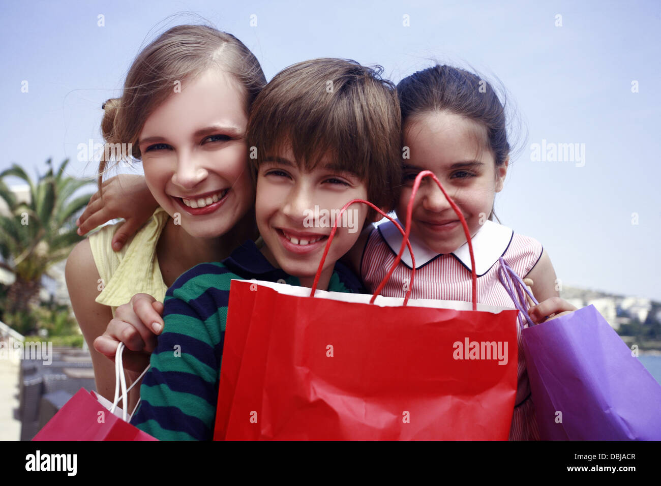 Mother and two children with shopping bags Stock Photo - Alamy