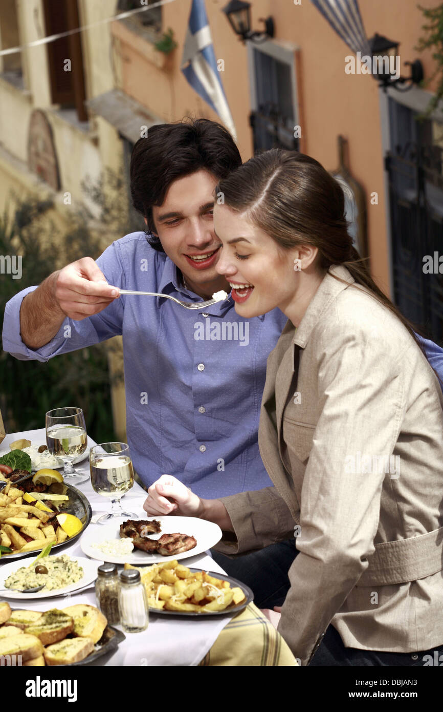 Man feeding woman at restaurant Stock Photo - Alamy