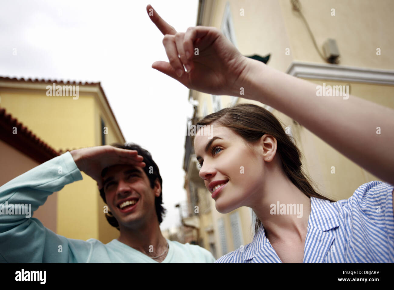 Woman pointing to show man the way Stock Photo - Alamy