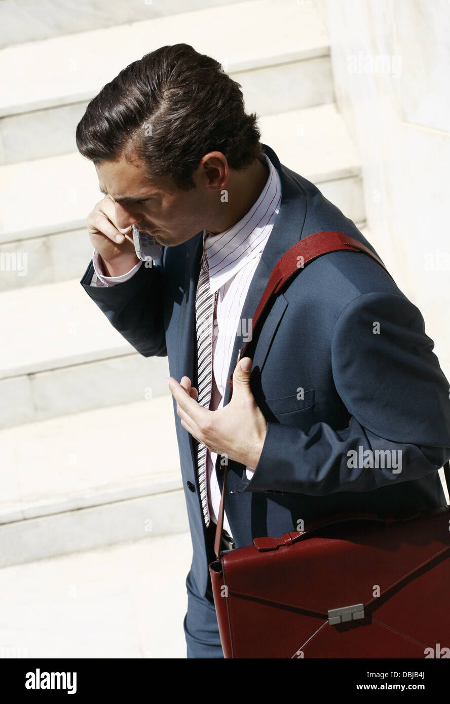 Businessman on the go on cell phone with briefcase Stock Photo - Alamy