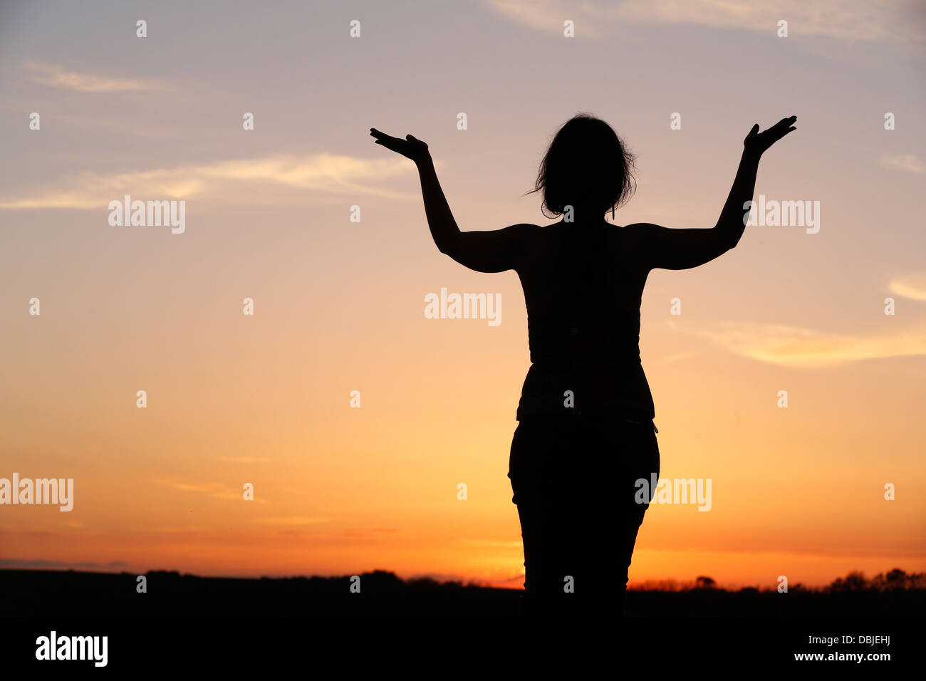 Woman praying at sunset Stock Photo - Alamy