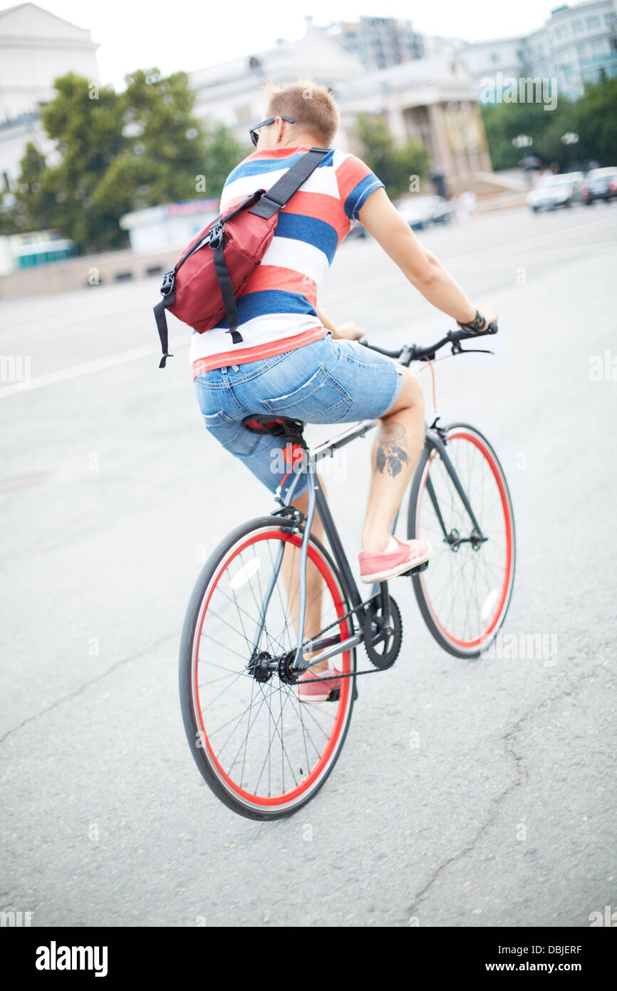Back view of youngguy riding bicycle in the city center Stock Photo - Alamy