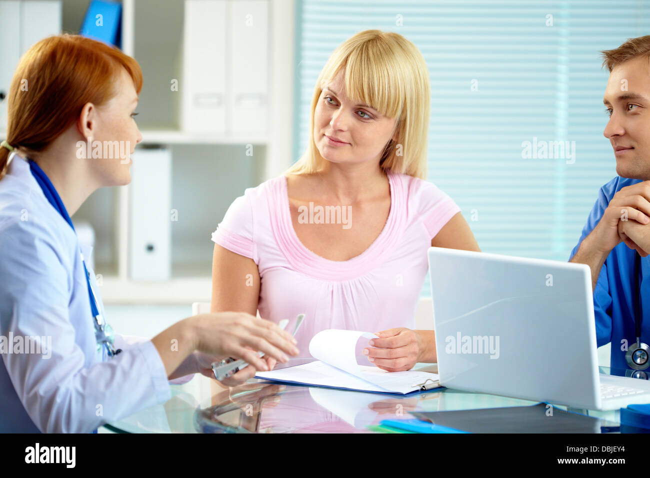 Portrait of confident practitioner and patient during consultation in ...