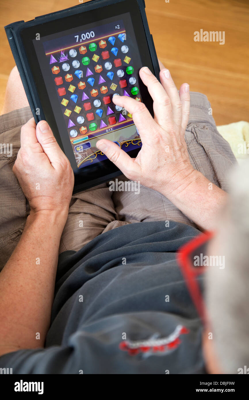 Man Playing Bejwelled Game on Ipad Stock Photo - Alamy