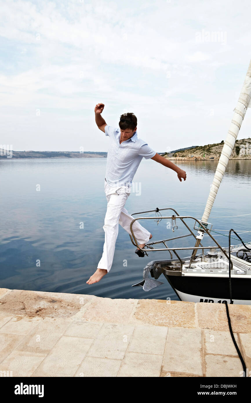 Croatia, Young man jumping onto pier Stock Photo - Alamy