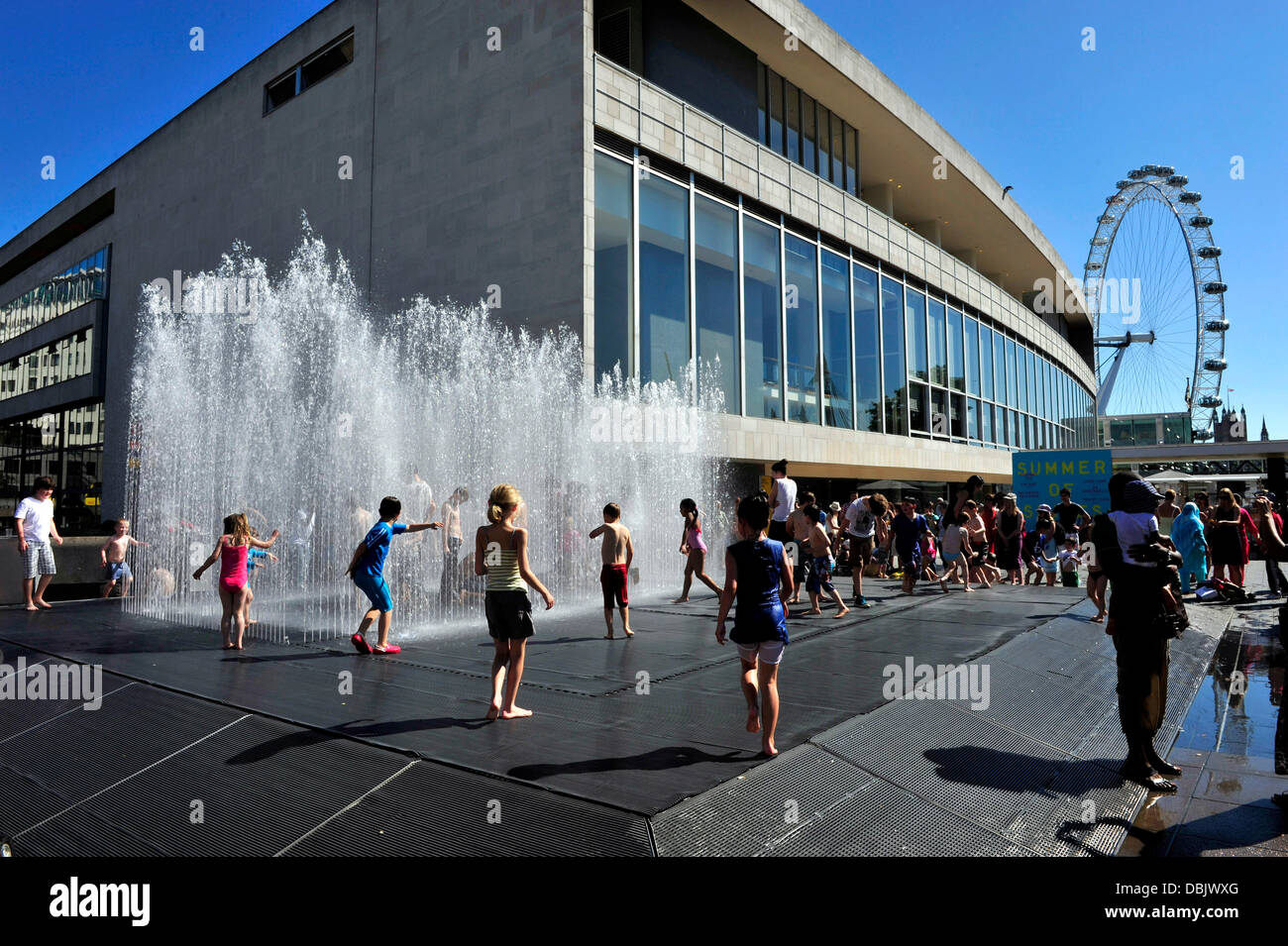 Adults and Children soak in a temporary water fountain on the South ...