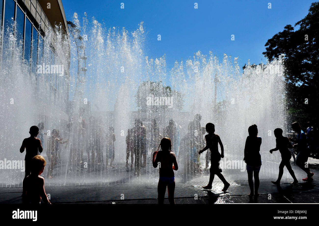 Adults and Children soak in a temporary water fountain on the South ...