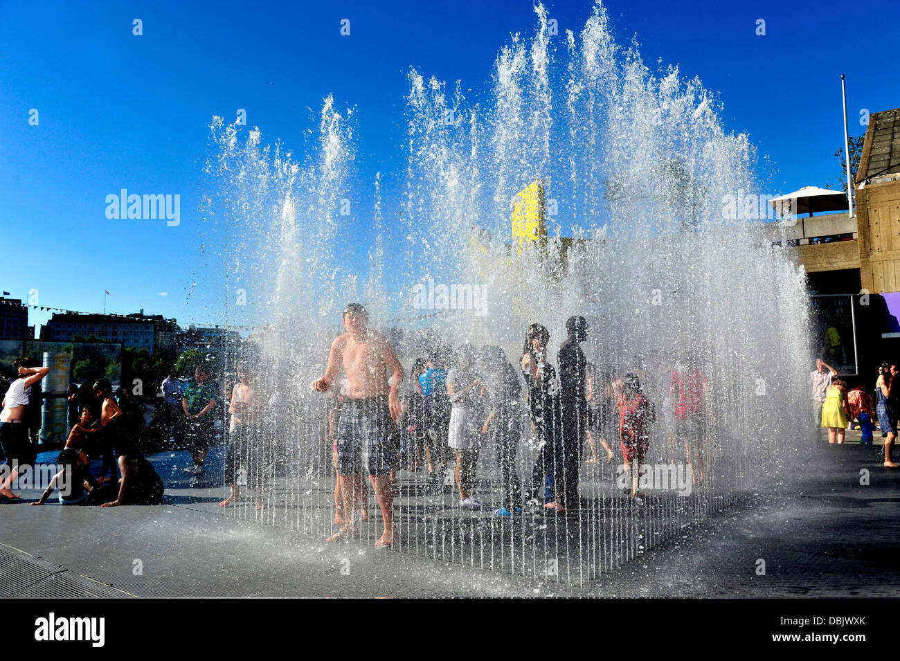 Adults and Children soak in a temporary water fountain on the South ...