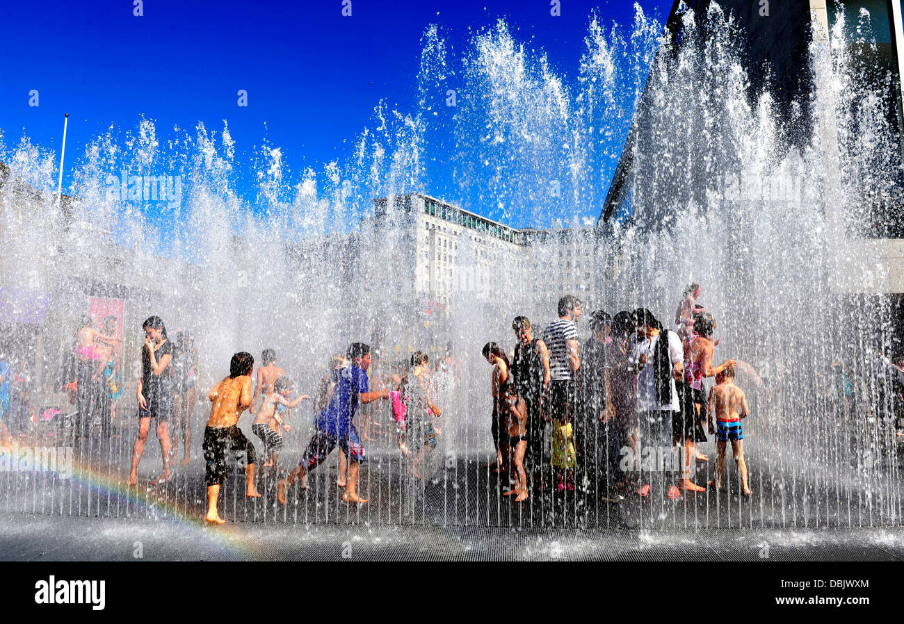 Adults and Children soak in a temporary water fountain on the South ...