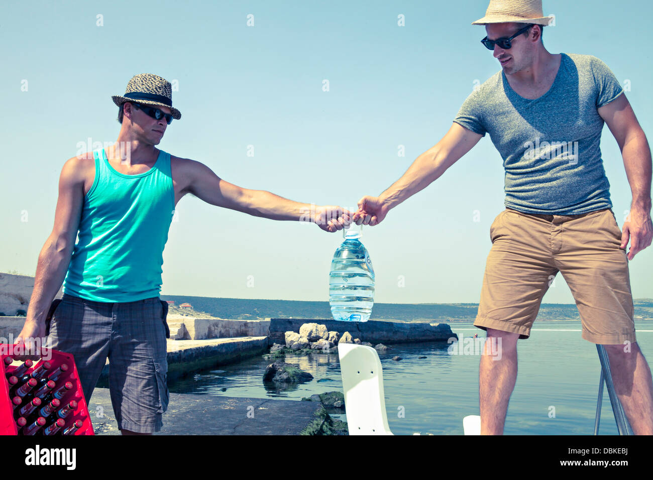 Croatia, Dalmatia, Young men at the seaside, transporting beer Stock ...