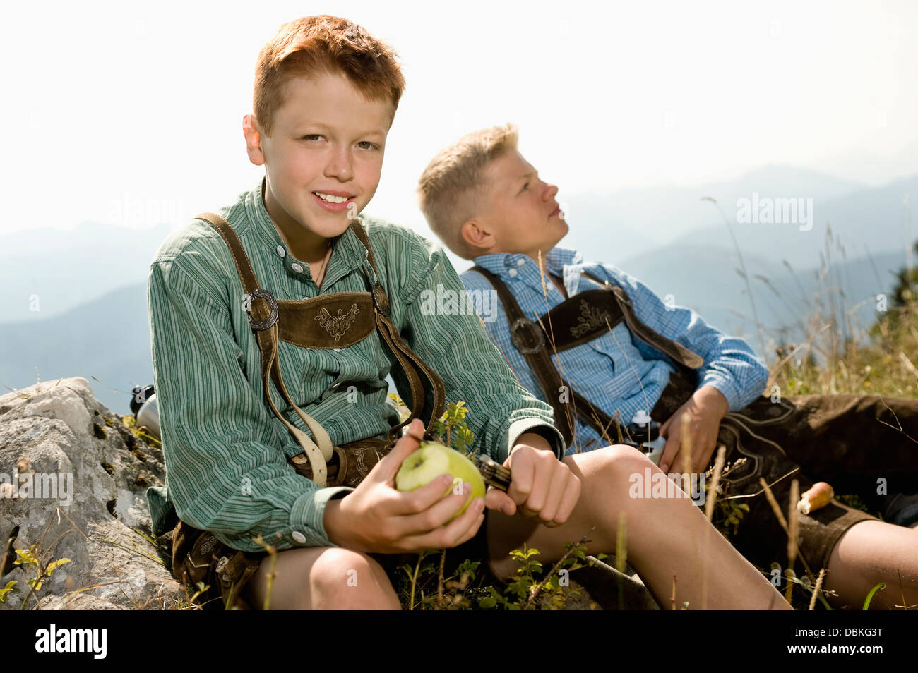 Germany, Bavaria, Two boys in traditional clothing taking a rest in ...