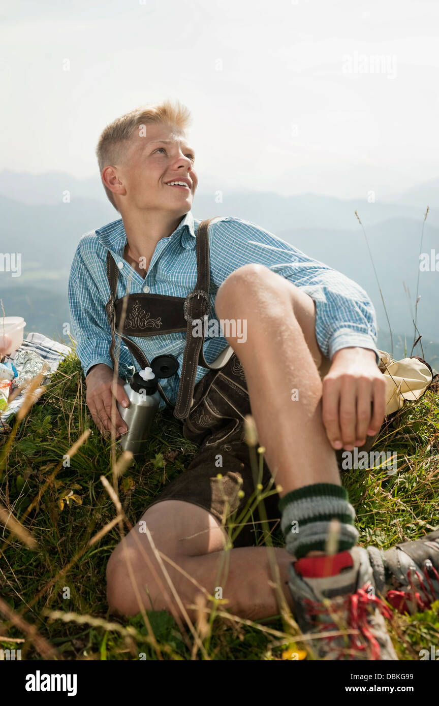 Germany, Bavaria, Boy in traditional clothing taking a rest in ...