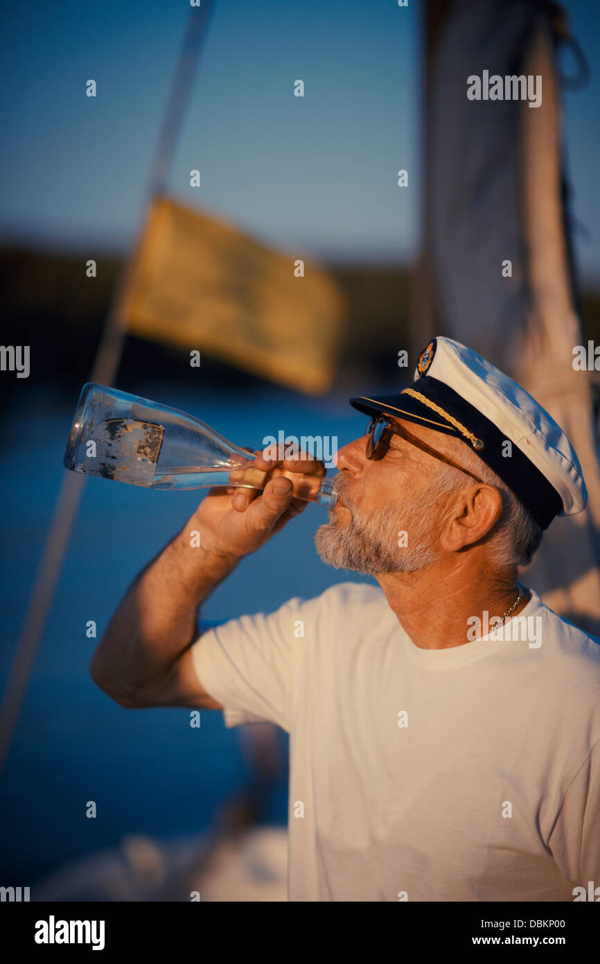 Croatia, Senior man with captain's hat drinking, side view Stock Photo ...