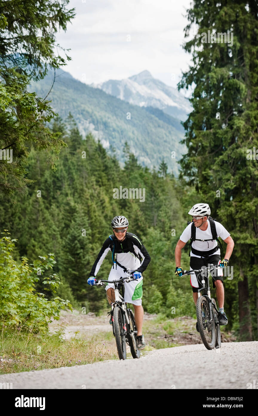 Two mountain bikers riding on road, Chiemgau, Bavaria, Germany Stock ...