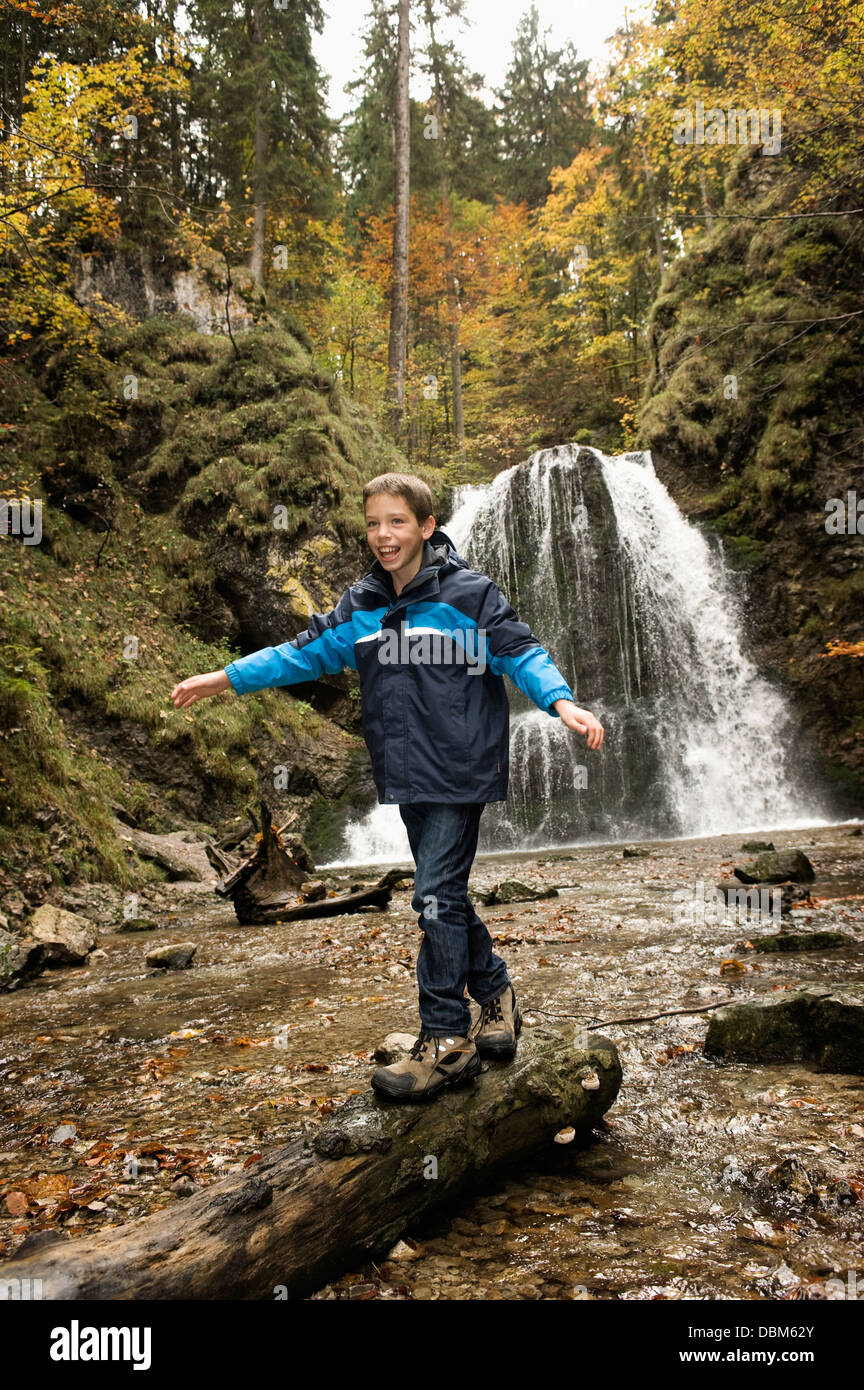 Boy walking on tree trunk hi-res stock photography and images - Alamy