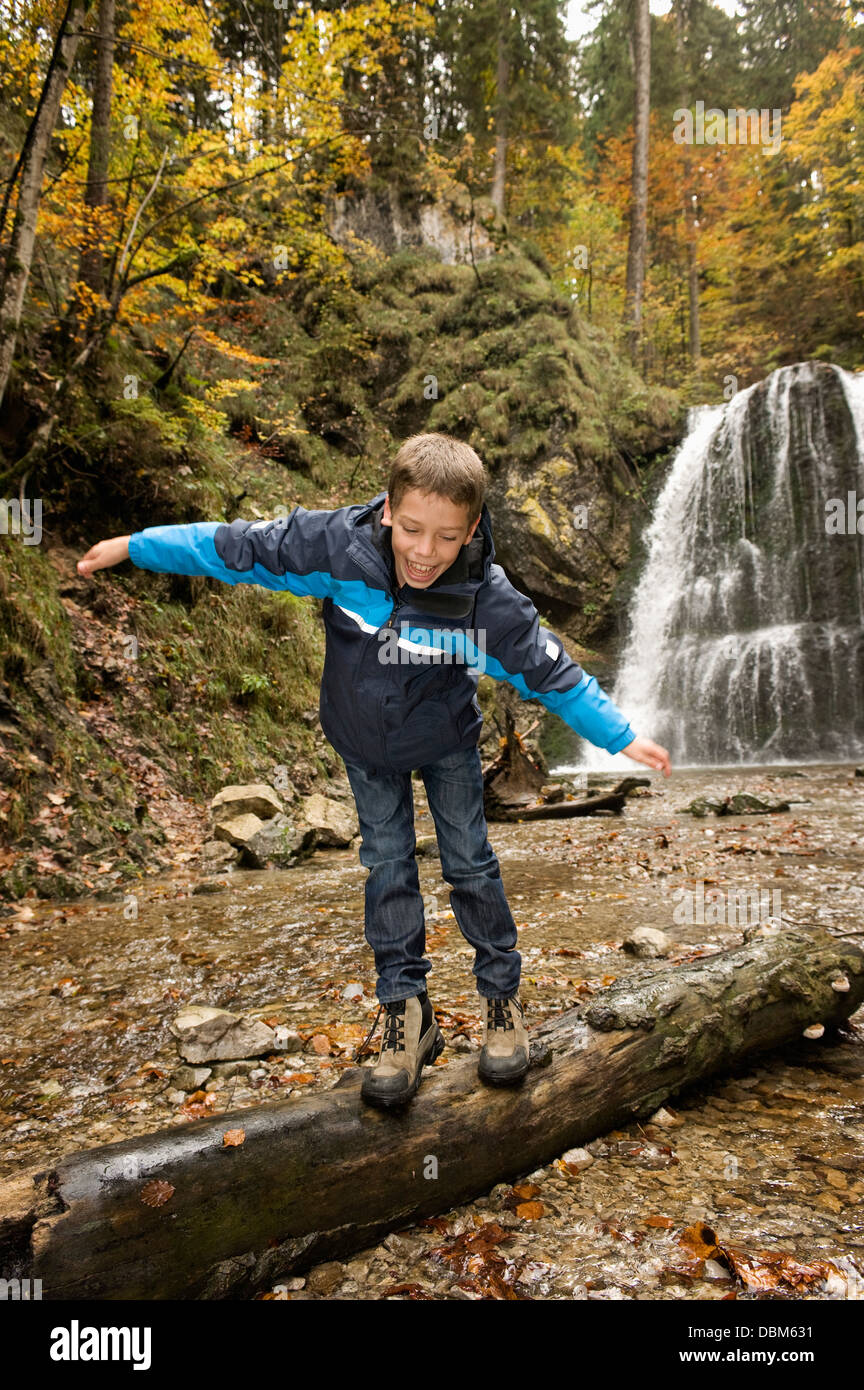 Boy walking on tree trunk hi-res stock photography and images - Alamy