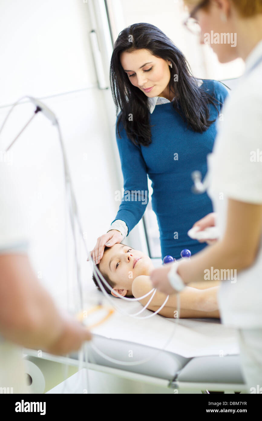 Female doctor examining boy, while mother consoles him, Osijek, Croatia ...