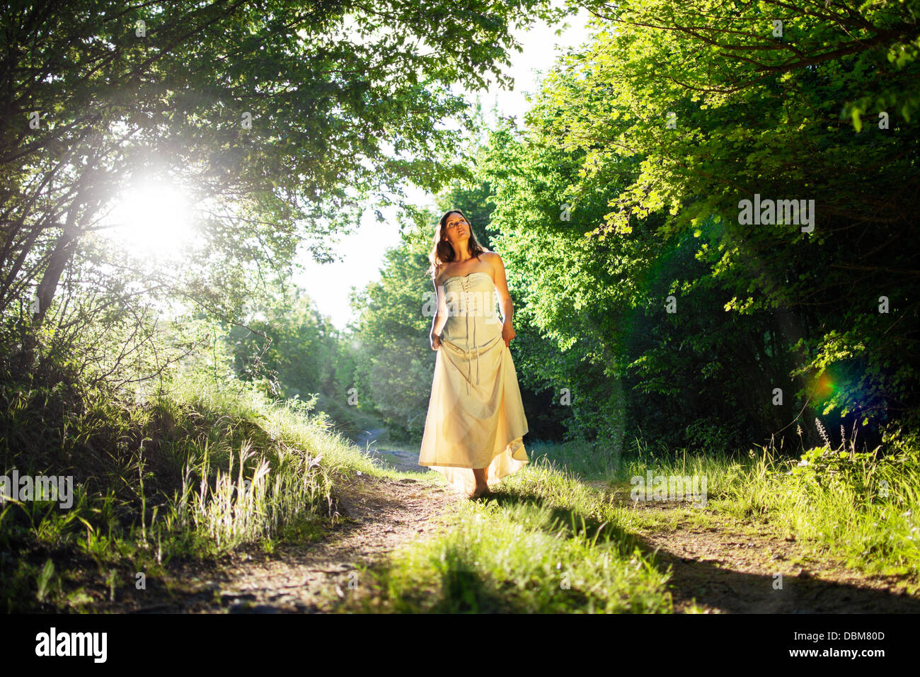 Beautiful young woman walking on a path in the forest Stock Photo - Alamy