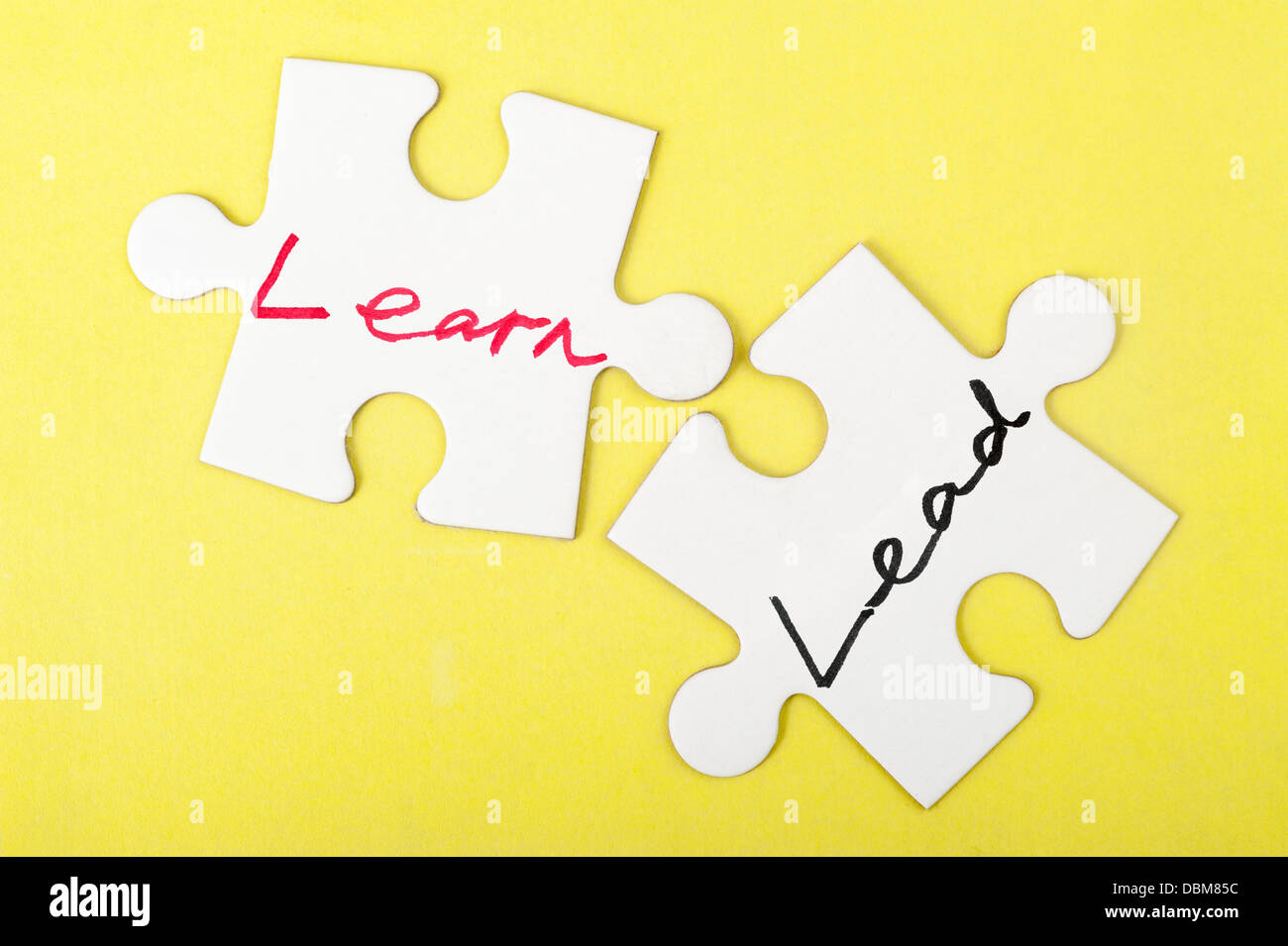 Lead and learn words written on two pieces of jigsaw puzzle Stock Photo ...